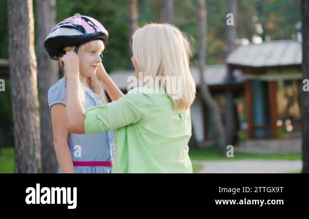 Mom puts on a protective helmet for her daughter. Concept - care and safety Stock Video Footage ...