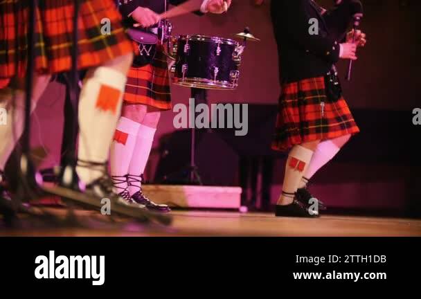 Traditional scottish band musicians in white socks and kilts singing ...
