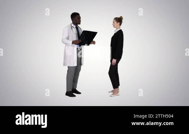 Full length. Physician showing a patient the X-ray results Then patient ...