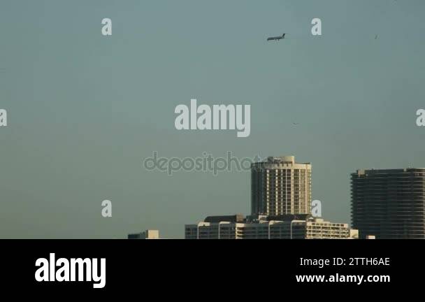 A commercial passenger jet flying over Miami ( right to left ), A ...