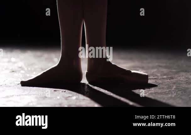 Female foot standing in spotlight on black background in studio. One ...