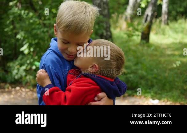 Little baby tenderly hugging and kissing his older brother. boy hugging ...