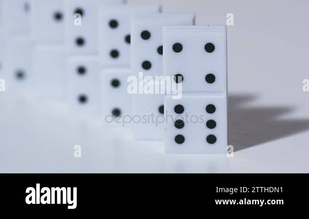 Dominos falling down pushed by person in slow-motion, chain reaction ...