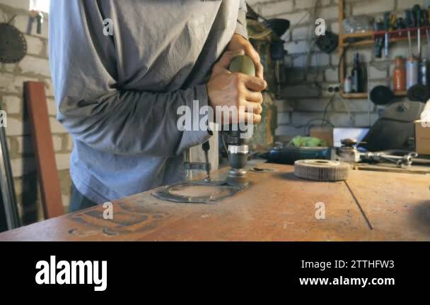 Hands of mechanic hold tool during operation. Man works in his garage ...
