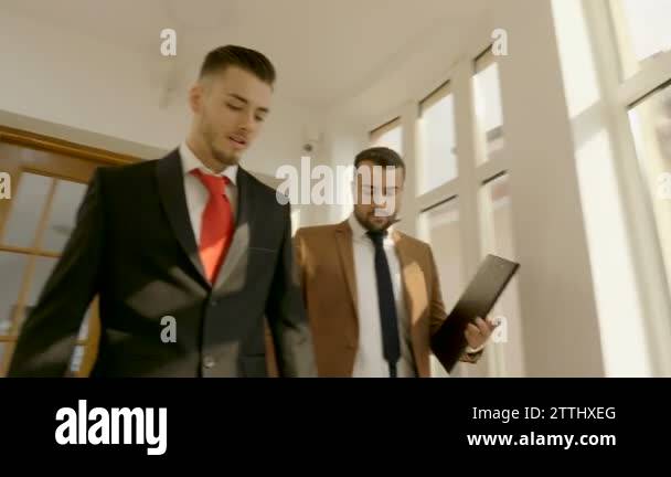 Two successful businessmen going on the stairs of an office building ...