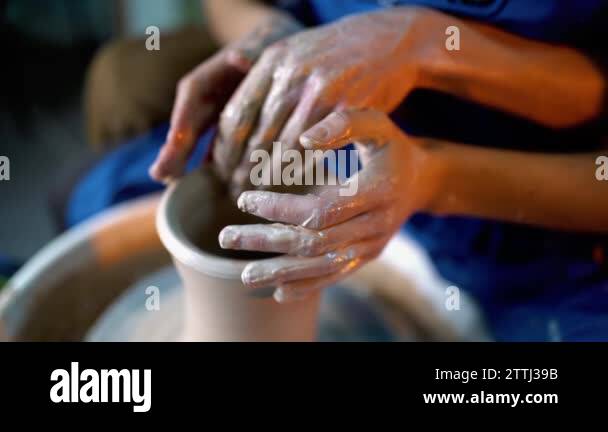 Hands of potter and his female student. Man and woman working together ...