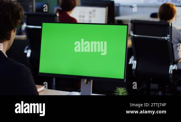 Office worker taping on the PC computer with green screen in the office ...