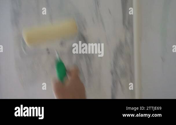 applying Wallpaper paste to the wall with a roller,preparation for ...