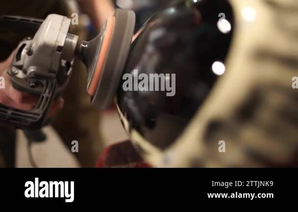 Guy polishing metal gas tank with sandpaper. Auto mechanic assembles ...