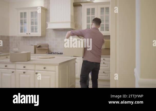 Bearded man and pretty woman enter the kitchen, holding hands. Man ...