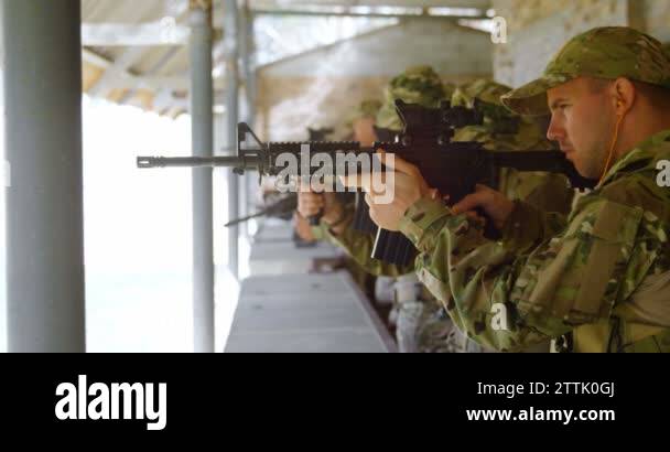 Side view of mixed-race military soldiers shooting rifle in target ...