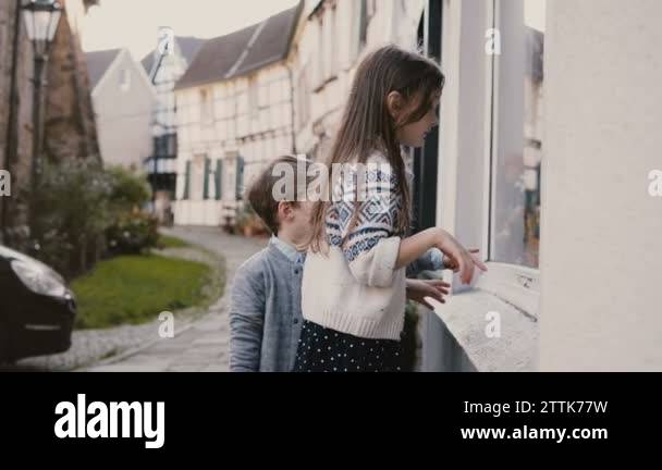Cute boy and girl choose gifts at toy storefront. Two Caucasian ...