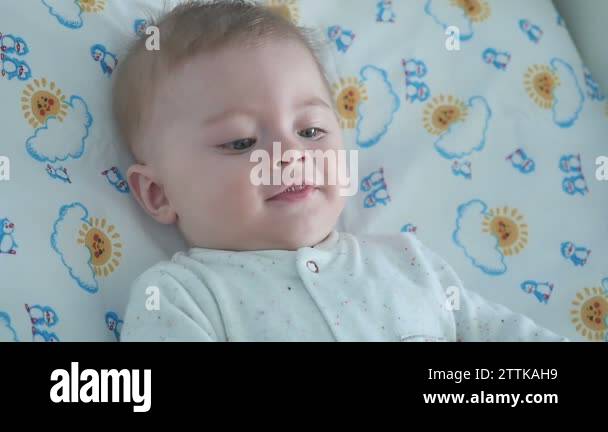 Close-up. Cute little baby is smiling, laying on the nappy. Smiling boy ...
