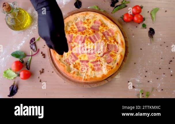 Chef sprinkle bacon pizza grated cheese. Hands in rubber gloves, top ...