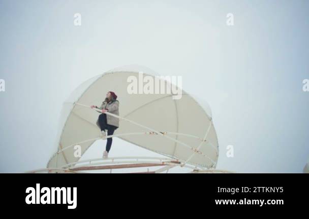 low angle shot beautiful girl stands on disassembled tent dome edge ...