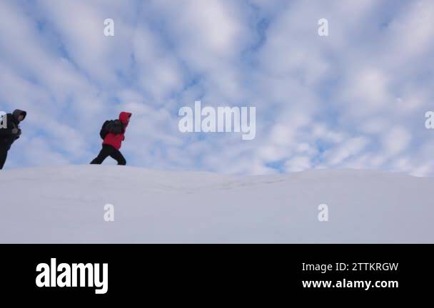 teamwork people in difficult conditions. climbers team in winter go to ...