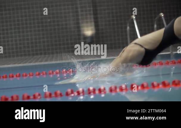 Woman swimmer jumping in deep water in swimming pool slow motion Stock ...