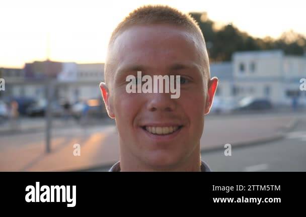 Portrait of young happy businessman looking and smiling into camera ...