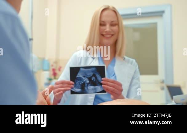 A doctor transmits a photograph of ultrasound scanning a happy couple ...