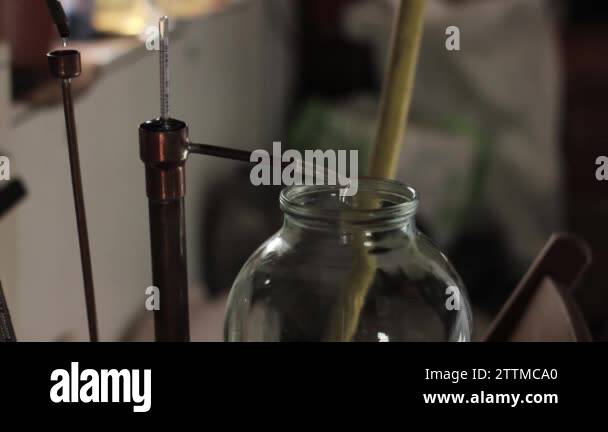 Alcohol distillation equipment, hooch fluid flow into glass jar Stock ...