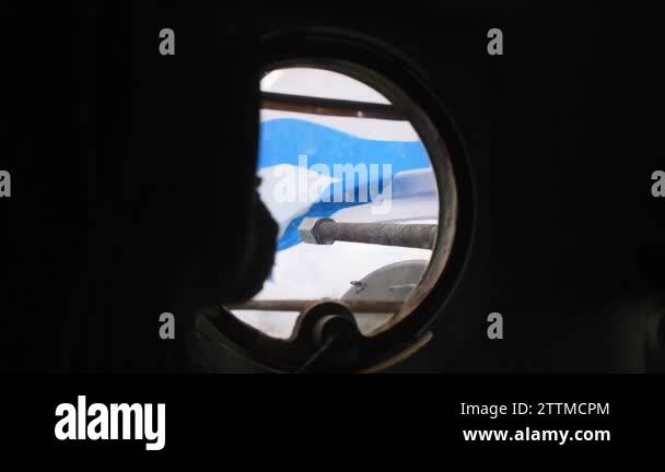 From the round window of an armored troop-carrier is seen a developing ...