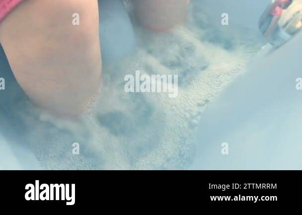 Hydromassage procedure. Close-up. The legs of an elderly woman in a ...