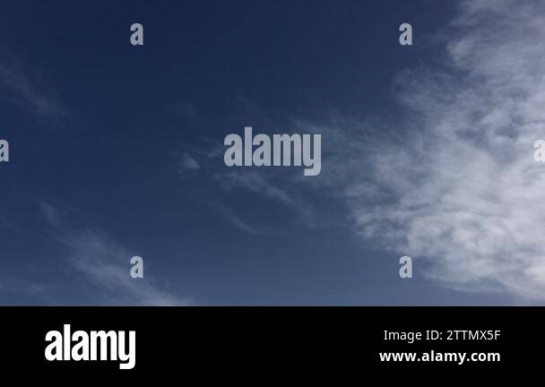 White clouds disappear in the hot sun on blue sky. Time-lapse motion ...