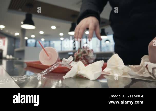 man cleans up or cleans garbage after meals or eating in a fast food ...