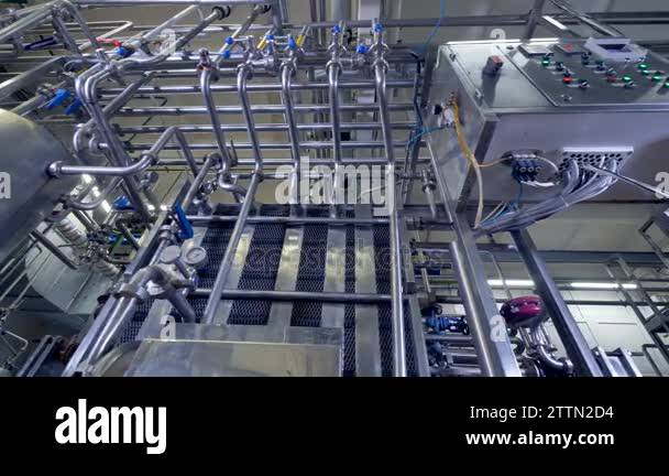 An extremely low view on a dairy factory control box connected to pipes ...