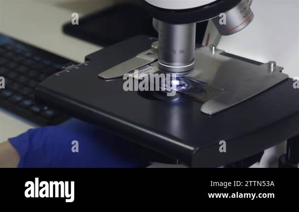 the student doctor analyzes the blood under a microscope. Closeup of a ...