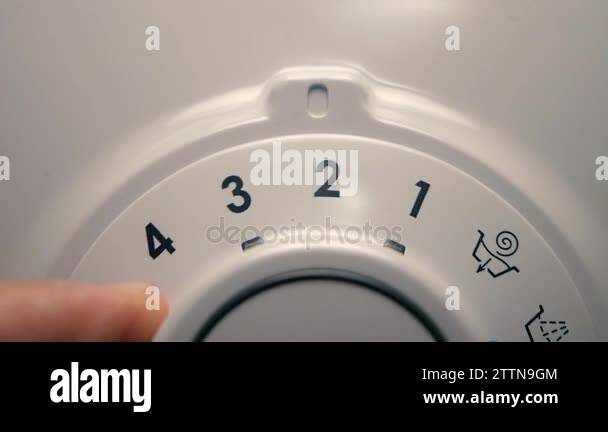 The man selects the washing program by rotating the selector of the ...