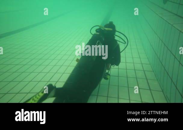 Back of diver in wetsuit with scuba swimming on bottom of pool Stock ...
