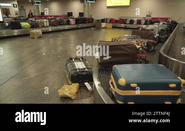 Suitcases in the baggage claim area are waiting for the owners who are ...