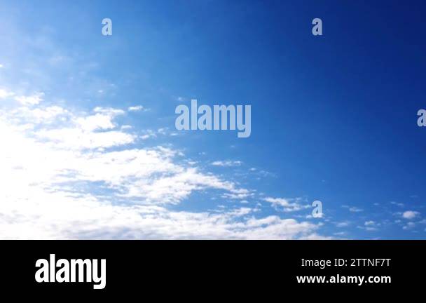White clouds disappear in the hot sun on blue sky. Time-lapse motion ...