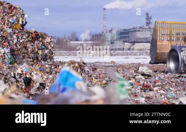 Enviromet pollution concept. Landfill tractor drives away near piles of ...