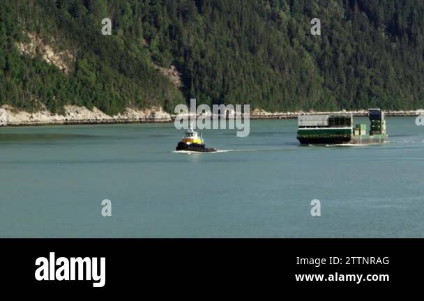 Tug boat pulling a cargo ship through the water in Alaska Stock Video ...