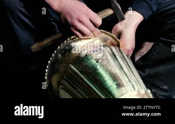 Traditional tinsmith work. Copper smith makes embossing artifacts from ...