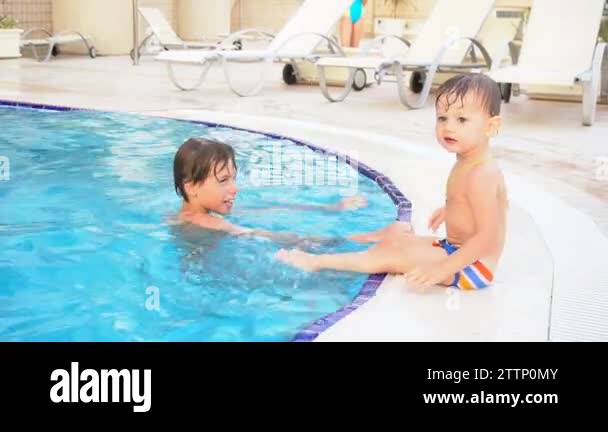 two boys brother bathe in the swimming pool at the resort Stock Video ...