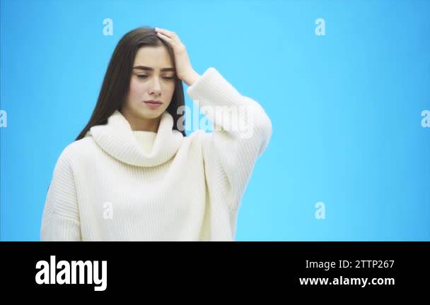 Young good business girl standing on a blue background. During this ...
