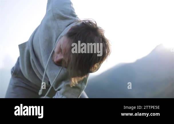 Man does morning exercise cross-touching feet rotating hands warm up ...