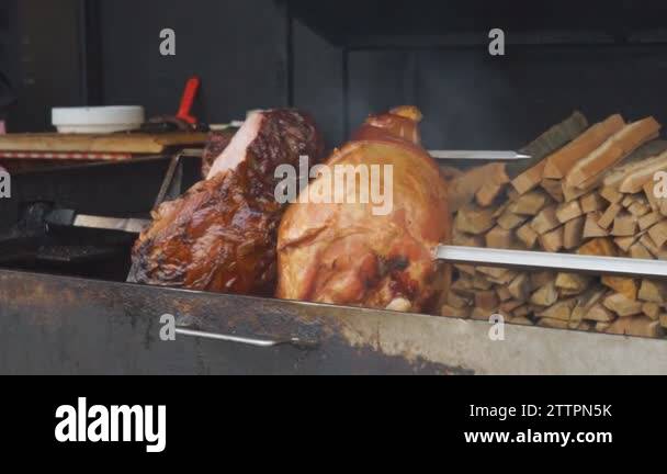 Appetizing grilled pork on the spit. Roasted leg of pork on traditional ...