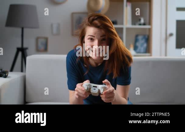 Determined girl playing a video game at home. Excited gamer woman ...