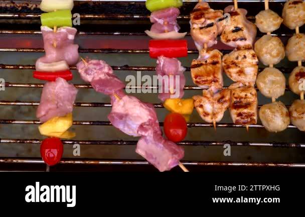 Traditional street food of Thailand. Cooking small kebabs on the grill ...