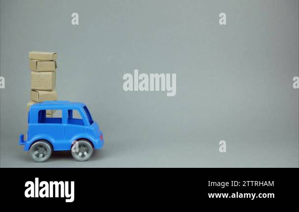 Blue toy car transports parcels over grey background. Parcel delivery ...
