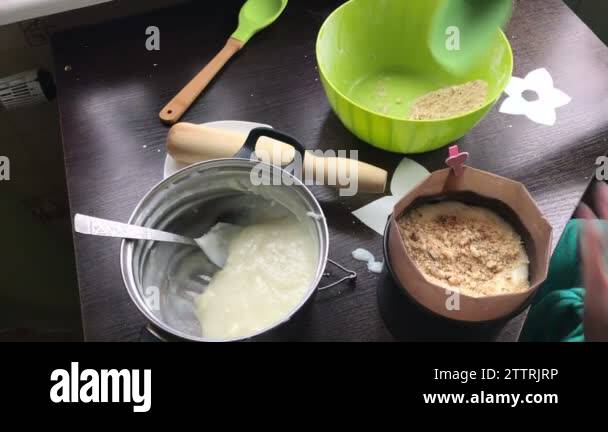 Woman adds sponge cake to cake mold. Cooking a cake of biscuit crumbs ...