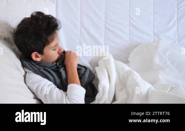 A sick baby boy was lying in bed with a fever, mama is caring for a ...