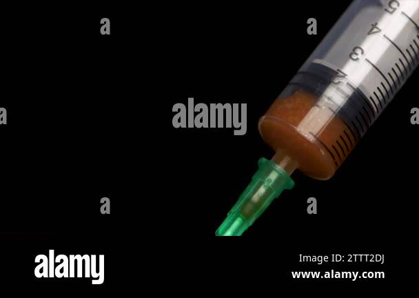 Taking vaccine into a glass syringe from a ampule on a black background ... Taking vaccine into a glass syringe from a ampule on a black background ...