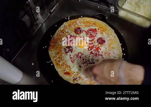 Cook preparing a crepe with cheese, Turkish sauge (sucuk) and egg Stock ...