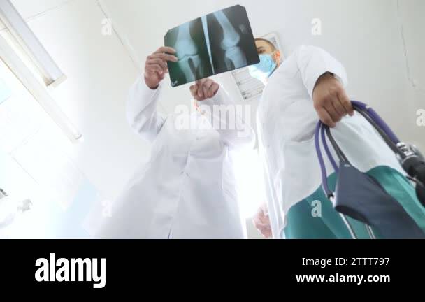 Male medics consult with each other while looking at x ray image. Two ...