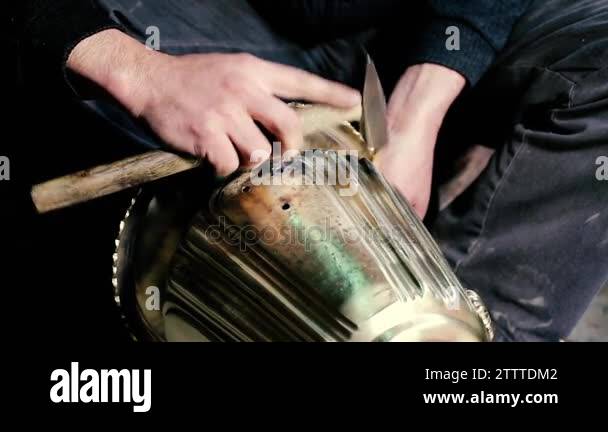 Traditional tinsmith work. Copper smith makes embossing artifacts from ...
